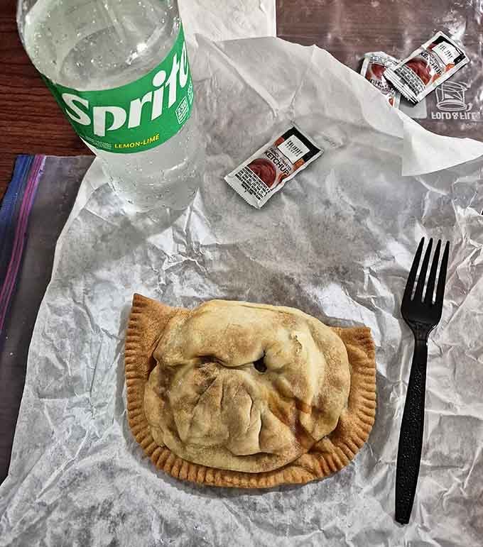 The classic pasty lunch setup: a hearty hand pie, cold Sprite, and enough ketchup packets to satisfy even the most enthusiastic dipper.