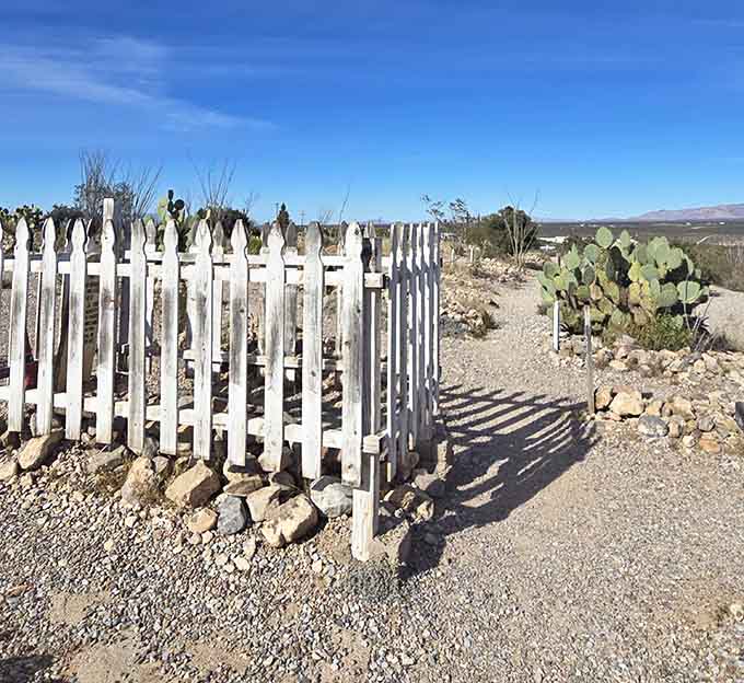 A white picket fence around a grave: because even in death, some people wanted to keep up with the Joneses.