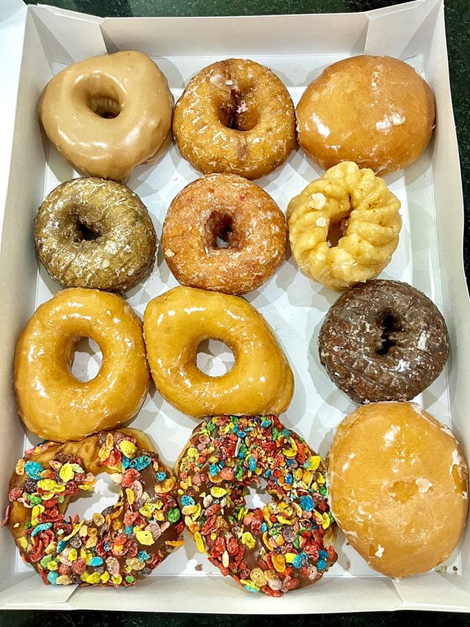A dozen reasons to cancel your diet plans, arranged in a box like edible jewels waiting to transform your morning from mundane to magnificent.
