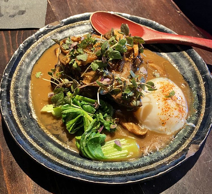 Tender braised short ribs rest in rich sauce with greens and a silky soft-cooked egg.