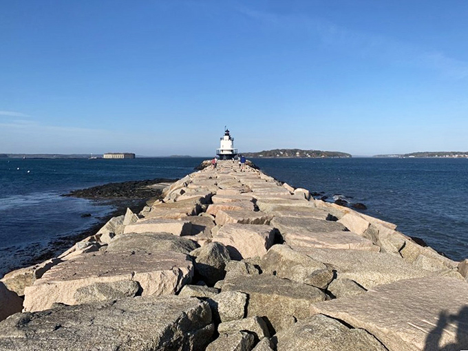The breakwater stretches like a stone finger into Casco Bay, leading visitors on a journey that feels both timeless and quintessentially Maine.