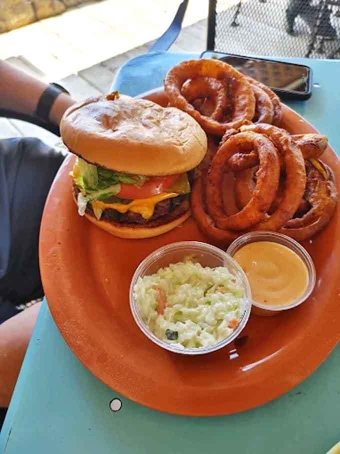 A burger that requires both hands and several napkins, paired with onion rings that could make a grown person weep with joy.