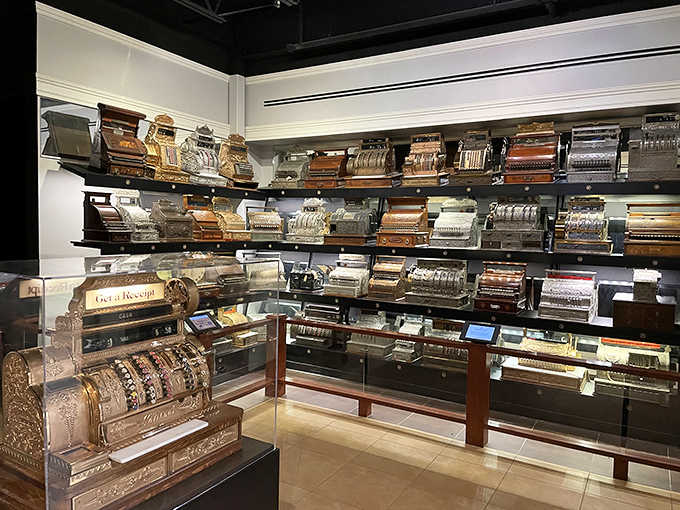 Vintage cash registers line the walls in gleaming formation, each one a mechanical marvel that once revolutionized retail before digital technology made buttons go "boop."