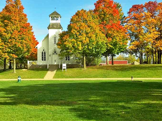 This pristine white church stands surrounded by autumn's glory, its simple elegance a testament to the central role faith played in early communities.
