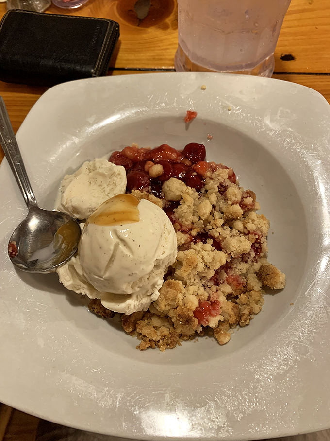 Berry cobbler that whispers sweet nothings to your spoon – warm, bubbling fruit beneath a golden crust, crowned with slowly melting ice cream.