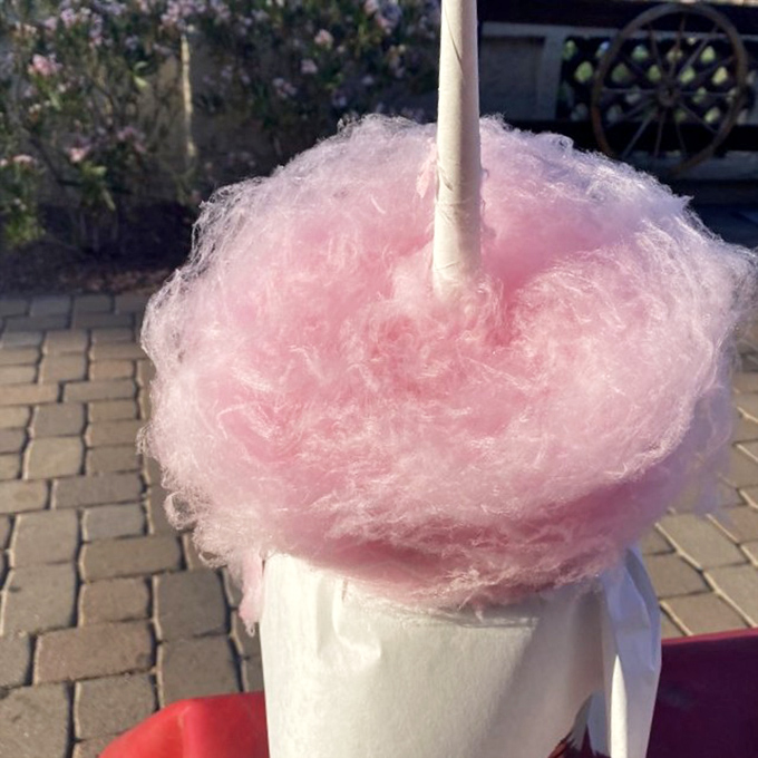 Pink cotton candy towers arrive at tables to gasps of delight – a nostalgic carnival treat elevated to Instagram-worthy status.