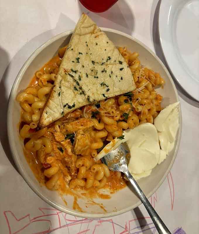 Pasta crowned with garlic bread like a carbohydrate king wearing a delicious crown, because sometimes you need carbs on top of your carbs.
