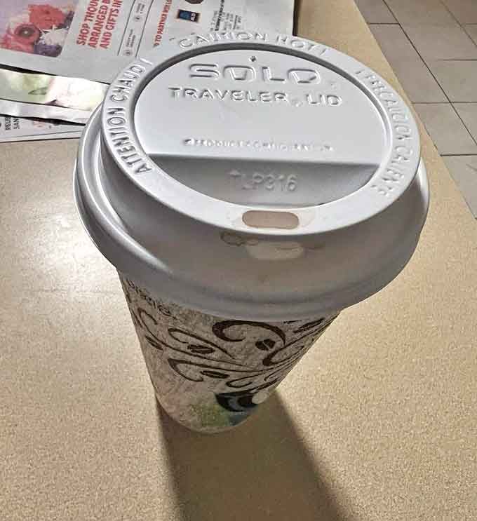 That plastic lid is the only thing standing between you and caffeinated bliss &ndash; the perfect companion for donut adventures.