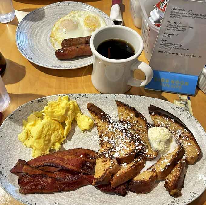French toast dusted with powdered sugar alongside crispy bacon and fluffy eggs, delivering the breakfast trifecta that makes mornings worth waking up for.