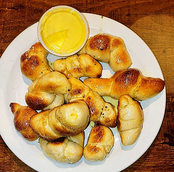These aren't just garlic knots &ndash; they're buttery, golden pillows of joy that might make you forget the pizza is coming. Almost.