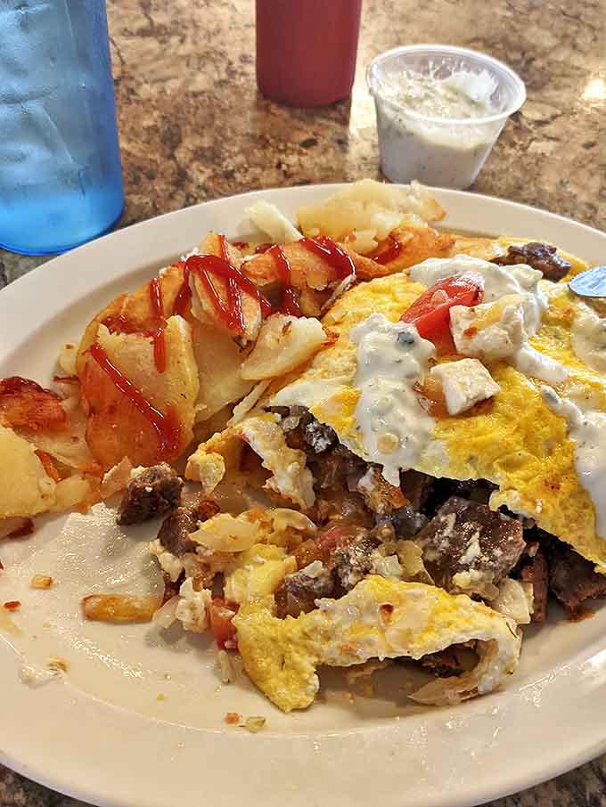 Morning glory on a plate: a Greek omelet loaded with savory ingredients and a side of golden home fries.
