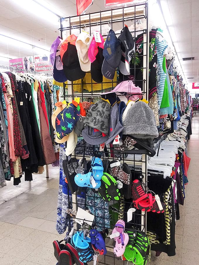 A headwear history lesson displayed on metal racks. From trucker caps advertising defunct local businesses to church hats that witnessed countless Sunday services.