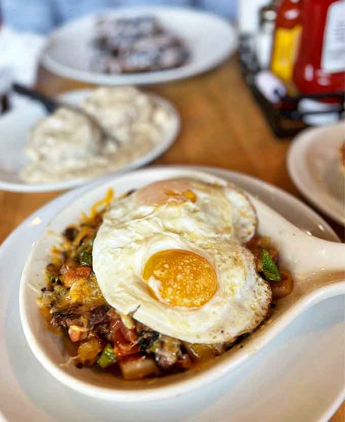 The Pot Roast Skillet arrives like breakfast's answer to comfort food, topped with an egg that's ready for its close-up.