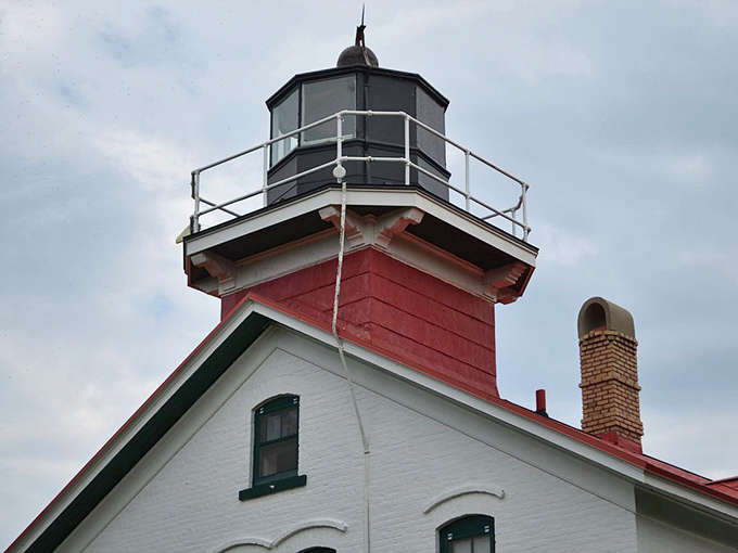 The distinctive red and black lantern room crowns the lighthouse, housing the powerful beam that guided countless sailors safely to harbor.