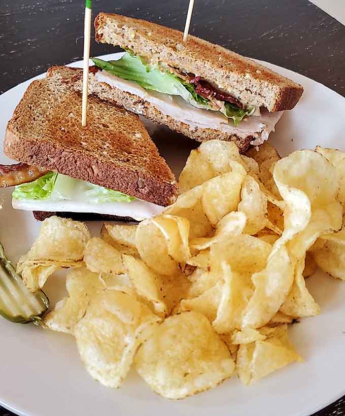 This club sandwich stacks turkey, bacon, and fresh vegetables between toasted bread, creating a tower of deliciousness that requires strategic eating.