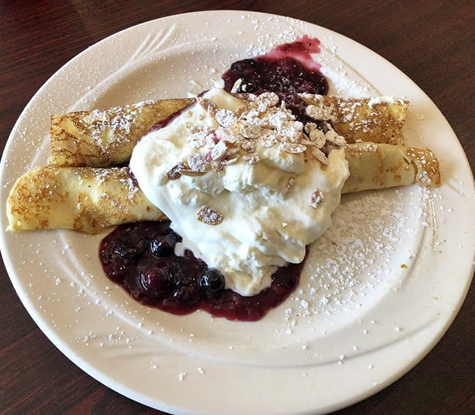 Delicate crepes wrapped around mixed berries create a lighter option that still satisfies, proving breakfast doesn't always require maximum density.