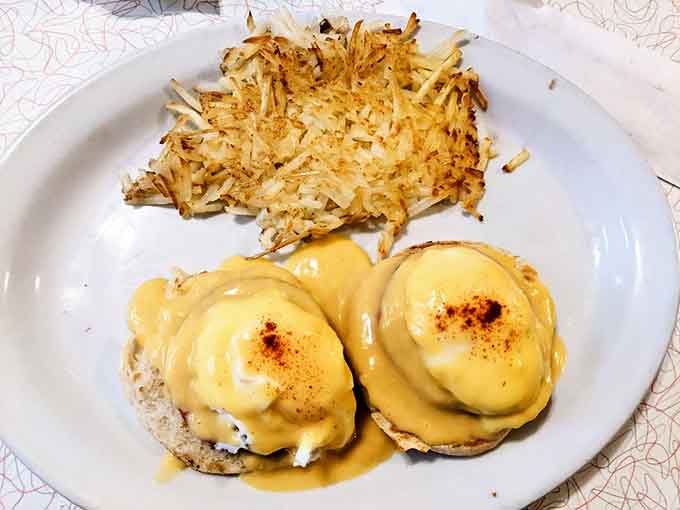 Eggs Benedict done right, with hollandaise sauce and hash browns that understand their important supporting role.
