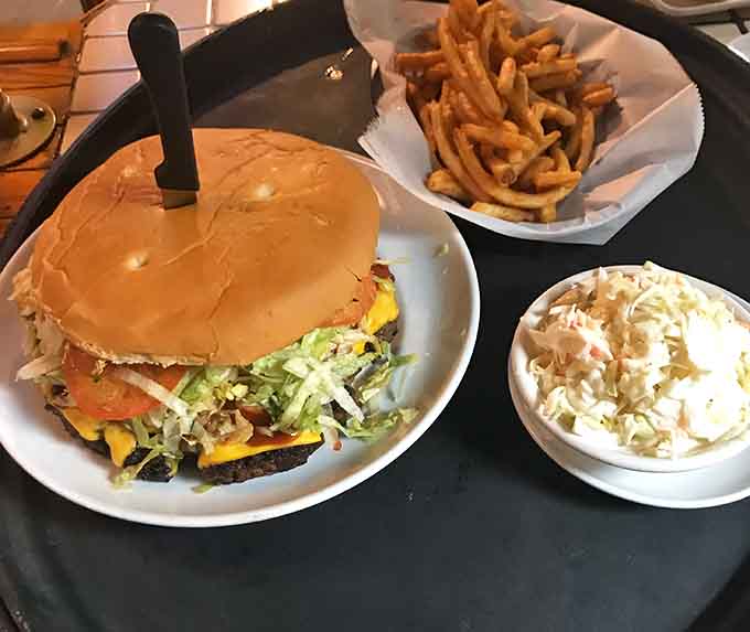 A burger loaded with fresh toppings, crispy fries, and creamy coleslaw, the holy trinity of tavern food.