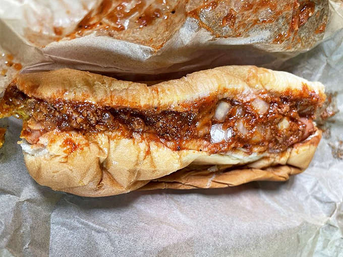 The star attraction in all its glory – a perfectly steamed bun cradling a snappy dog smothered in that gravity-defying signature chili.