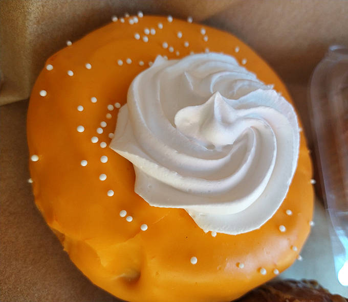 The Orange Creamsicle donut captures summer nostalgia in pastry form. That perfect swirl of whipped cream is practically begging for its close-up.