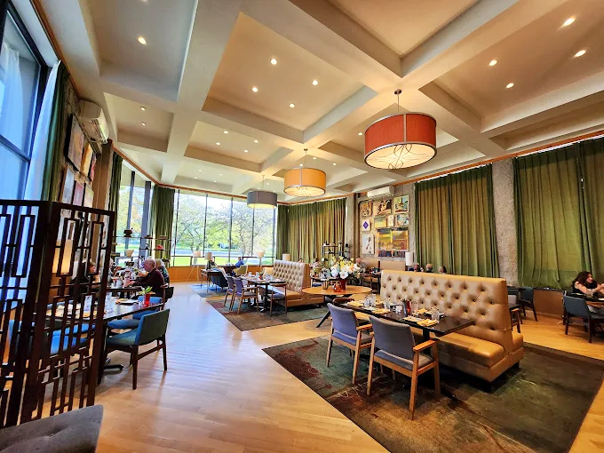 The dining room's warm wood and natural light create a sanctuary for serious food appreciation. Notice how nobody's looking at their phones?