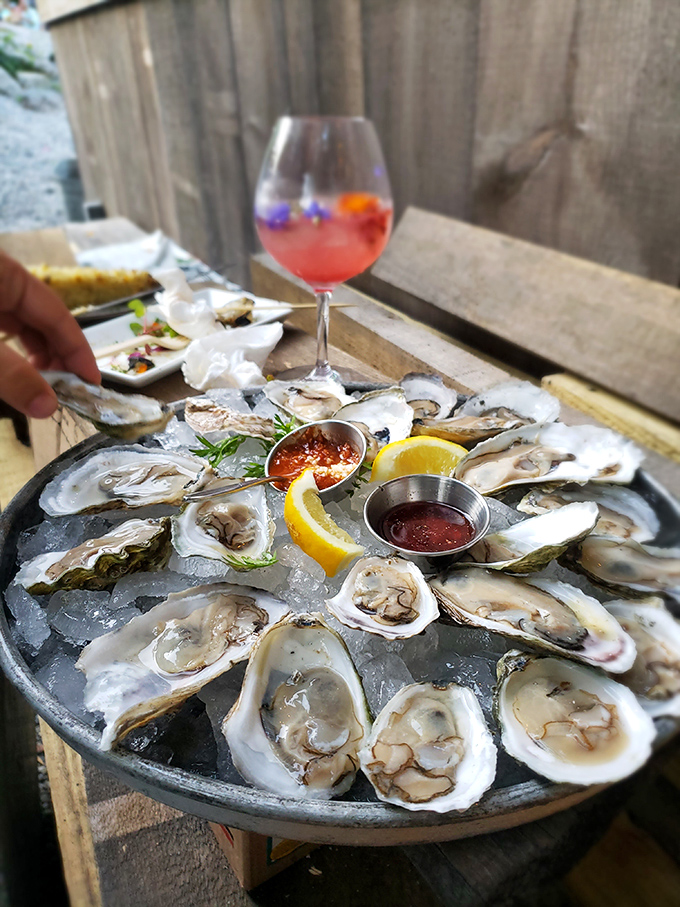 A platter of glistening oysters on ice, surrounded by mignonette and lemon &ndash; the ocean's perfect appetizer awaiting your indulgence.