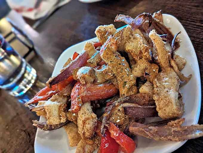 Calamari that ruins you for all other versions &ndash; tender morsels nestled among colorful peppers, proving appetizers can be main event worthy.