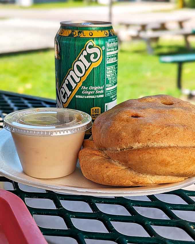 The perfect Upper Peninsula picnic: a hearty pasty, some gravy for dipping, and a cold drink on a sunny day.