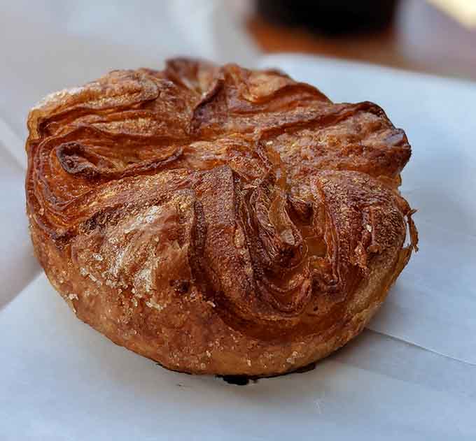The Kouign-Amann's caramelized layers create a texture symphony that crunches and melts simultaneously, defying physics and expectations.