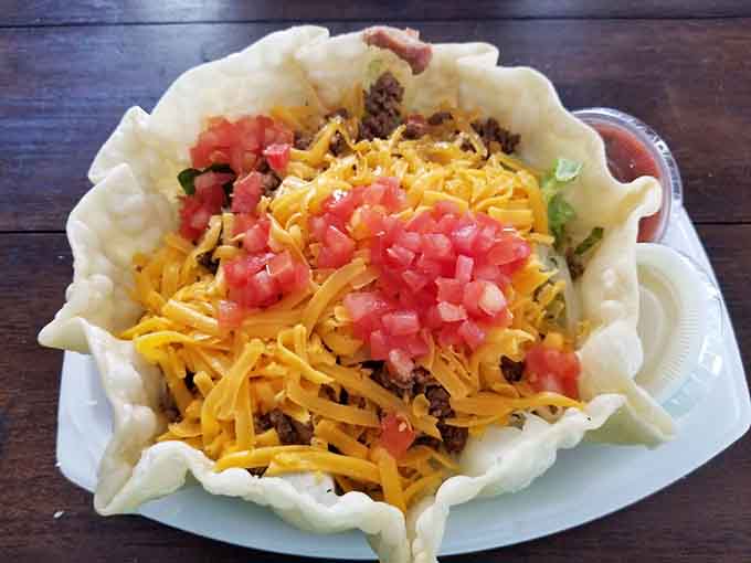The taco salad arrives in its edible bowl like a fiesta that decided to get comfortable and stay awhile.