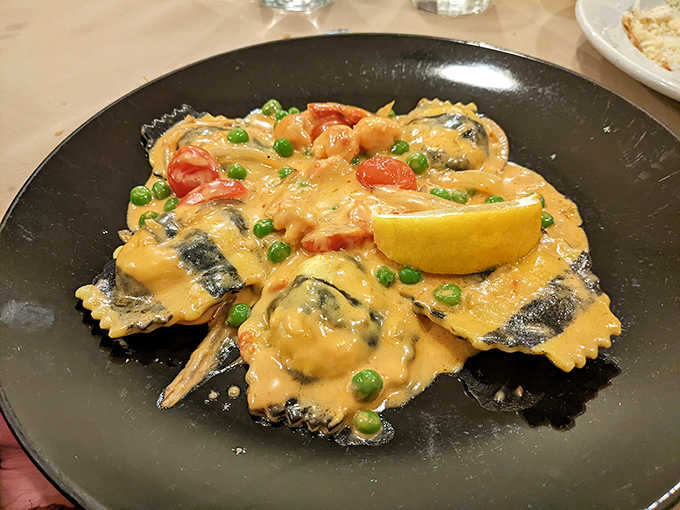 Pasta pillows swimming in a sunset-colored sauce, where seafood treasures hide within each tender fold.