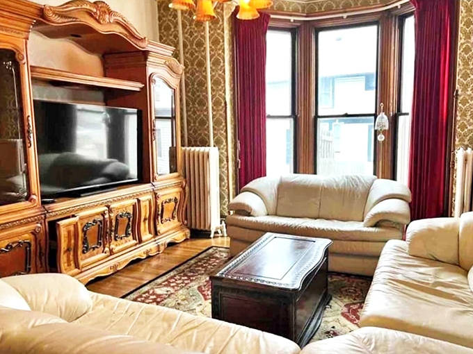 Bay windows flood this sitting area with natural light, creating the perfect spot to curl up with a book or pretend you're plotting a Victorian scandal.