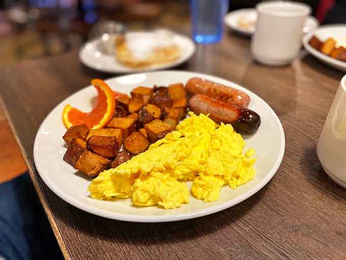 Breakfast sausage links nestled beside fluffy scrambled eggs and golden home fries &ndash; the holy trinity of morning satisfaction.