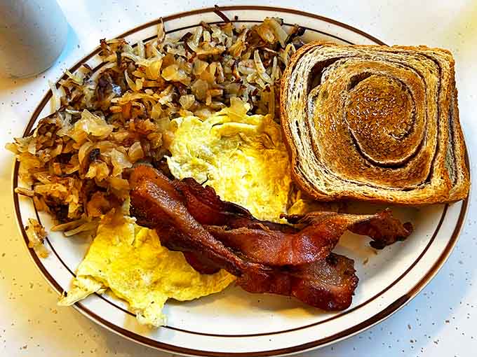 Breakfast perfection: fluffy scrambled eggs, crispy yet tender hash browns, perfectly cooked bacon, and toast that's exactly the right shade of golden.