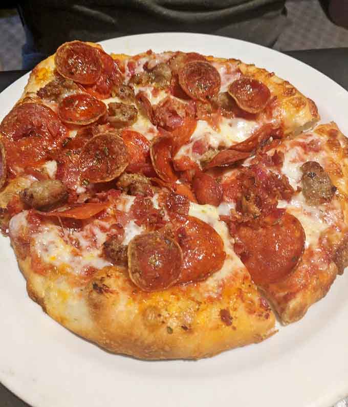 Pepperoni and sausage cover this beauty like a delicious blanket, with cheese bubbling around the edges in golden perfection.