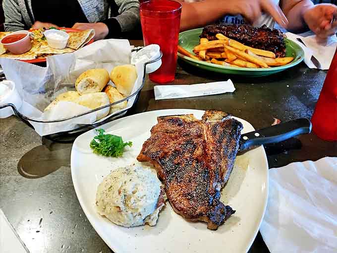 The T-bone arrives with theatrical sizzle &ndash; a carnivore's dream alongside golden fries and fresh-baked rolls.