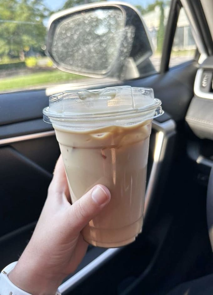 An iced latte in your car cup holder is basically a portable vacation from whatever stress you're currently avoiding.