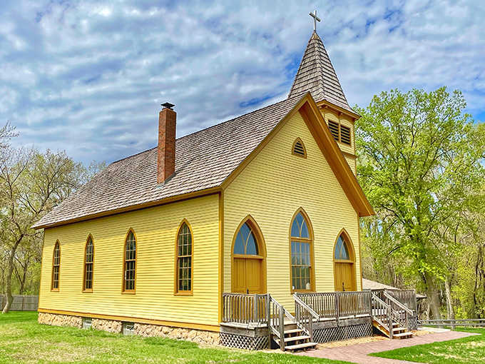 Sunshine bathes the cheerful yellow church, its simple beauty a testament to faith that sustained pioneers through harsh Minnesota winters.