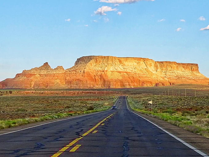 Navajo Mountain stands sentinel in the distance, its sacred profile visible for miles across the desert plains on clear days.