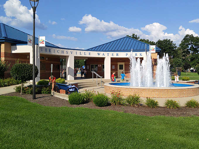 The welcoming facade of Uhrichsville Water Park promises aquatic adventures behind those brick walls and dancing fountains.