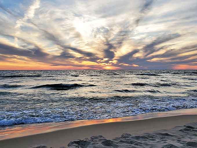 Waves perform their endless dance against the shore, a hypnotic rhythm that's been the soundtrack to Michigan summers since time began.