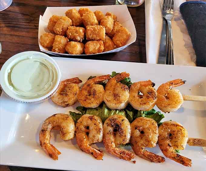 Grilled shrimp and crispy tots make an unlikely but delicious pairing on this appetizer plate.