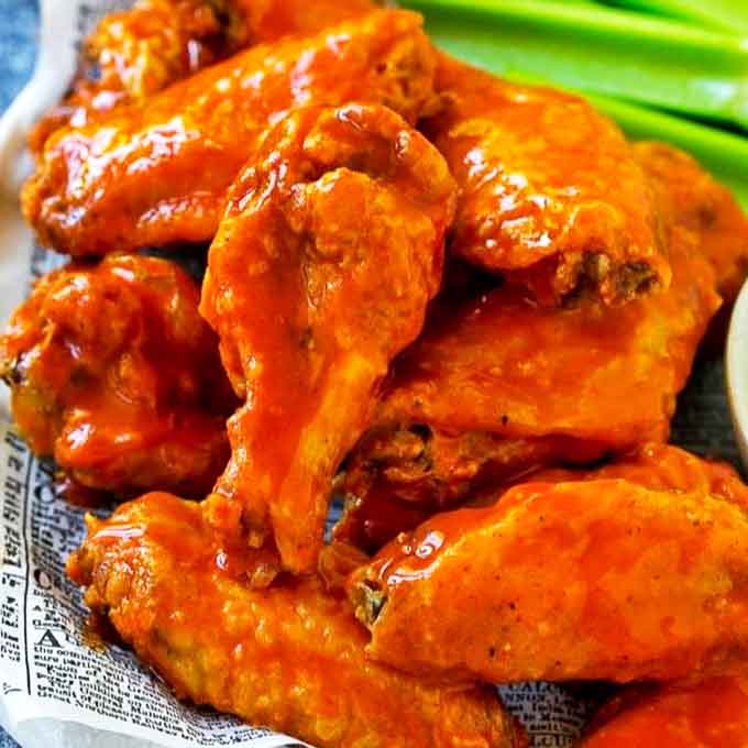Buffalo wings glistening with that signature orange-red sauce. The vibrant color promises a flavor explosion that delivers with every bite.