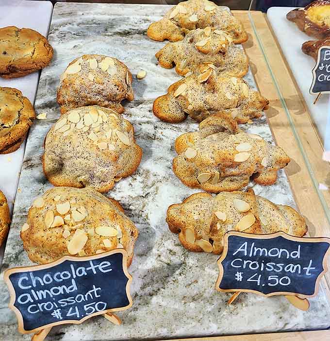 Almond croissants lined up like delicious soldiers, ready to battle your hunger with their crispy, nutty armor and sweet interior.