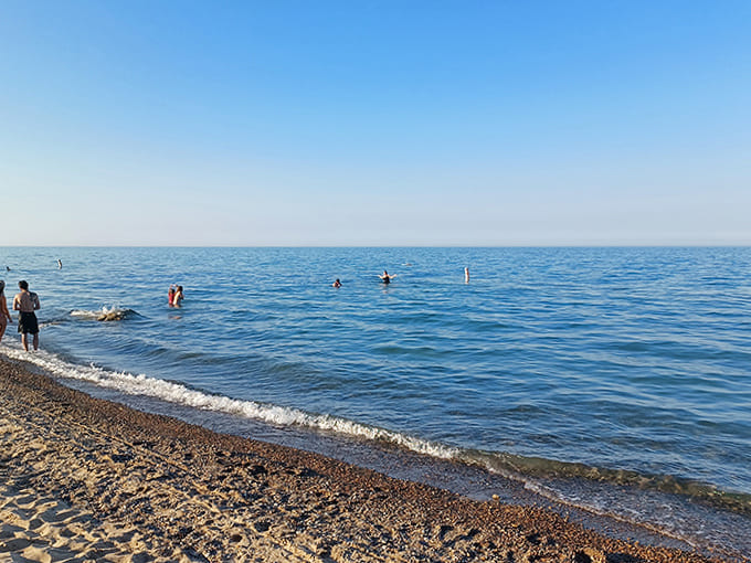 Lake Huron's crystal waters invite swimmers to cool off, proving you don't need a passport for world-class beach experiences.