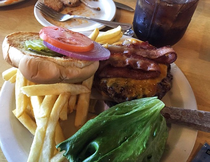 Simple pleasures done right &ndash; a perfectly grilled burger with crispy fries and fresh garnishes makes for an iconic American road trip meal.