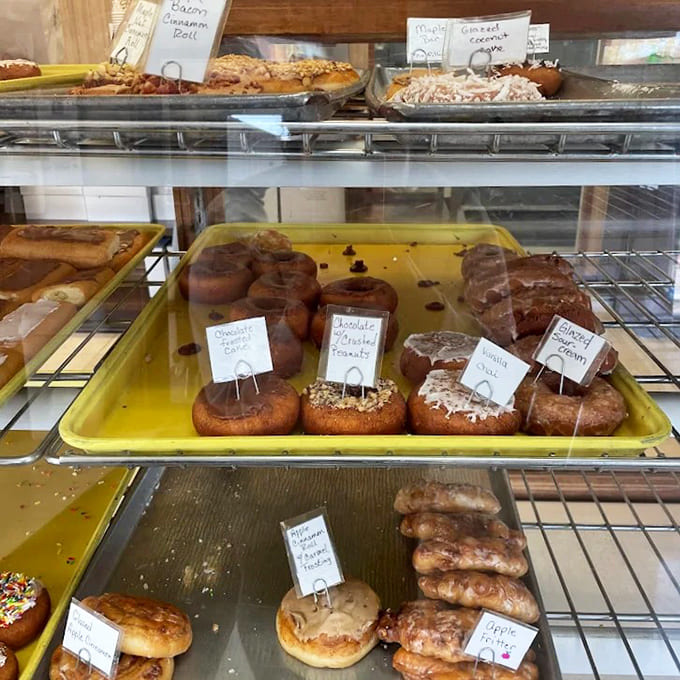 The display case reveals rows of freshly made temptations, each labeled with handwritten care &ndash; a sweet museum where everything's meant to be devoured.