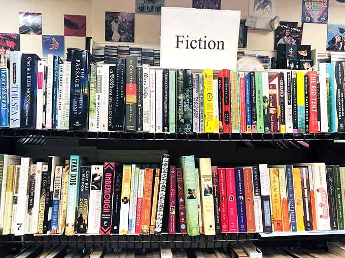 The fiction section houses everything from dog-eared classics to contemporary page-turners, each spine promising a different escape.
