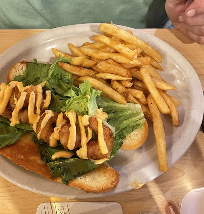 The shrimp po'boy arrives with golden fries and enough sauce to make you consider licking the plate when nobody's looking.