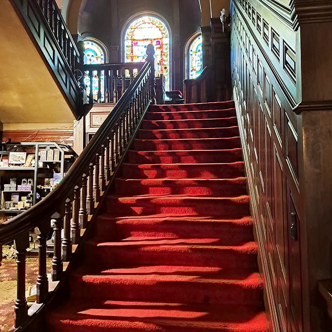 Red carpet cascades down the grand staircase, where visitors occasionally report feeling gentle, unexplained touches on their shoulders.